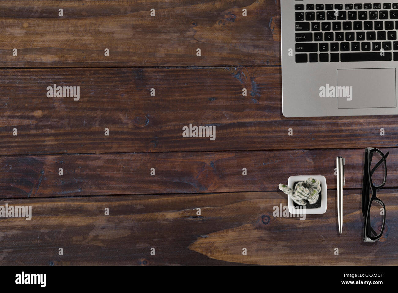 laptop computer, black eyeglasses, cactus pot and pen on wood office ...