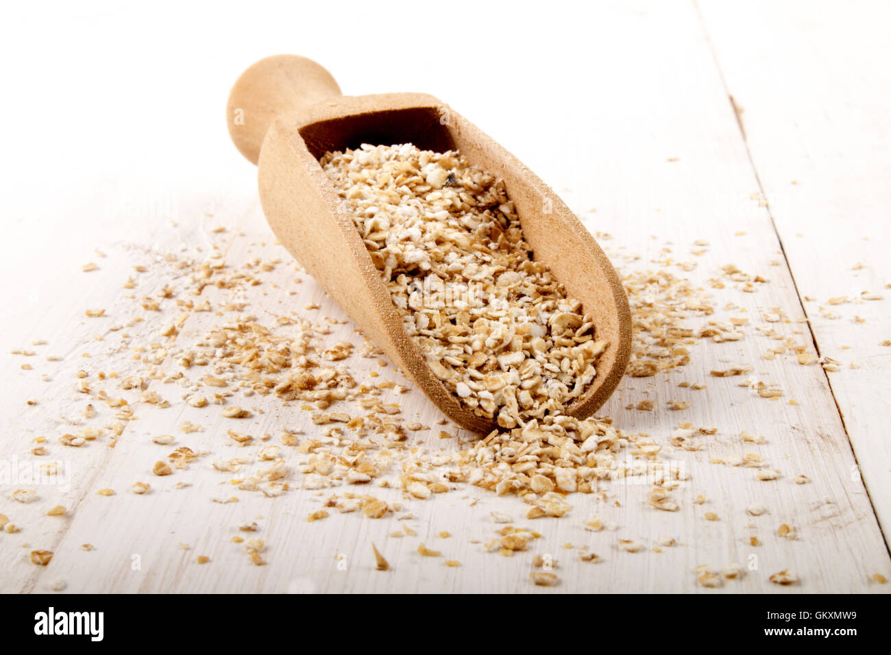 raw oat bran and wooden scoop on white wood Stock Photo - Alamy