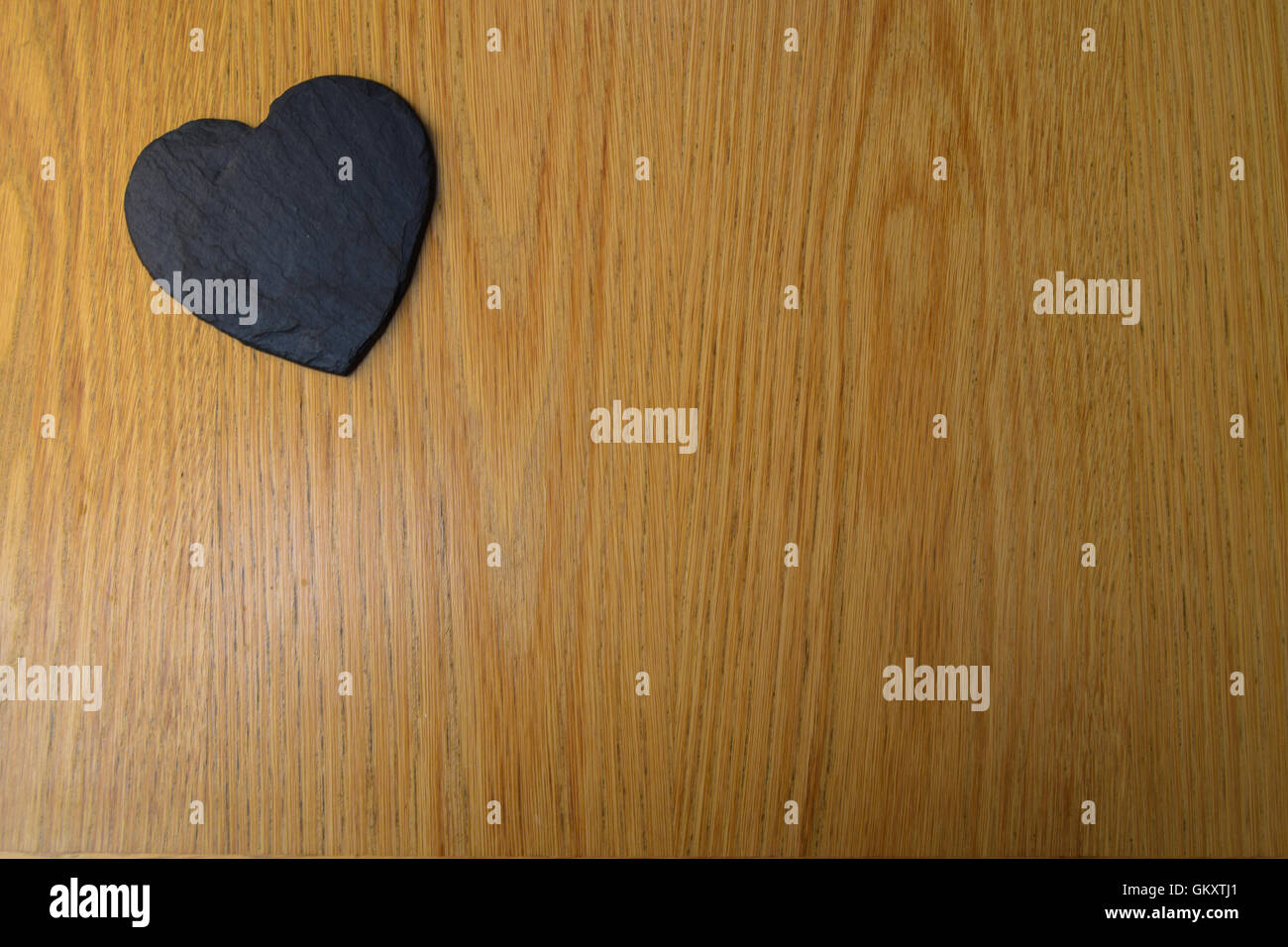Slate black heart on wooden table in the corner, sky view Stock Photo ...