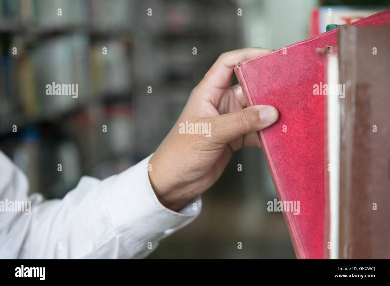 man searching book from textbook shelf in aisle in library Stock Photo ...