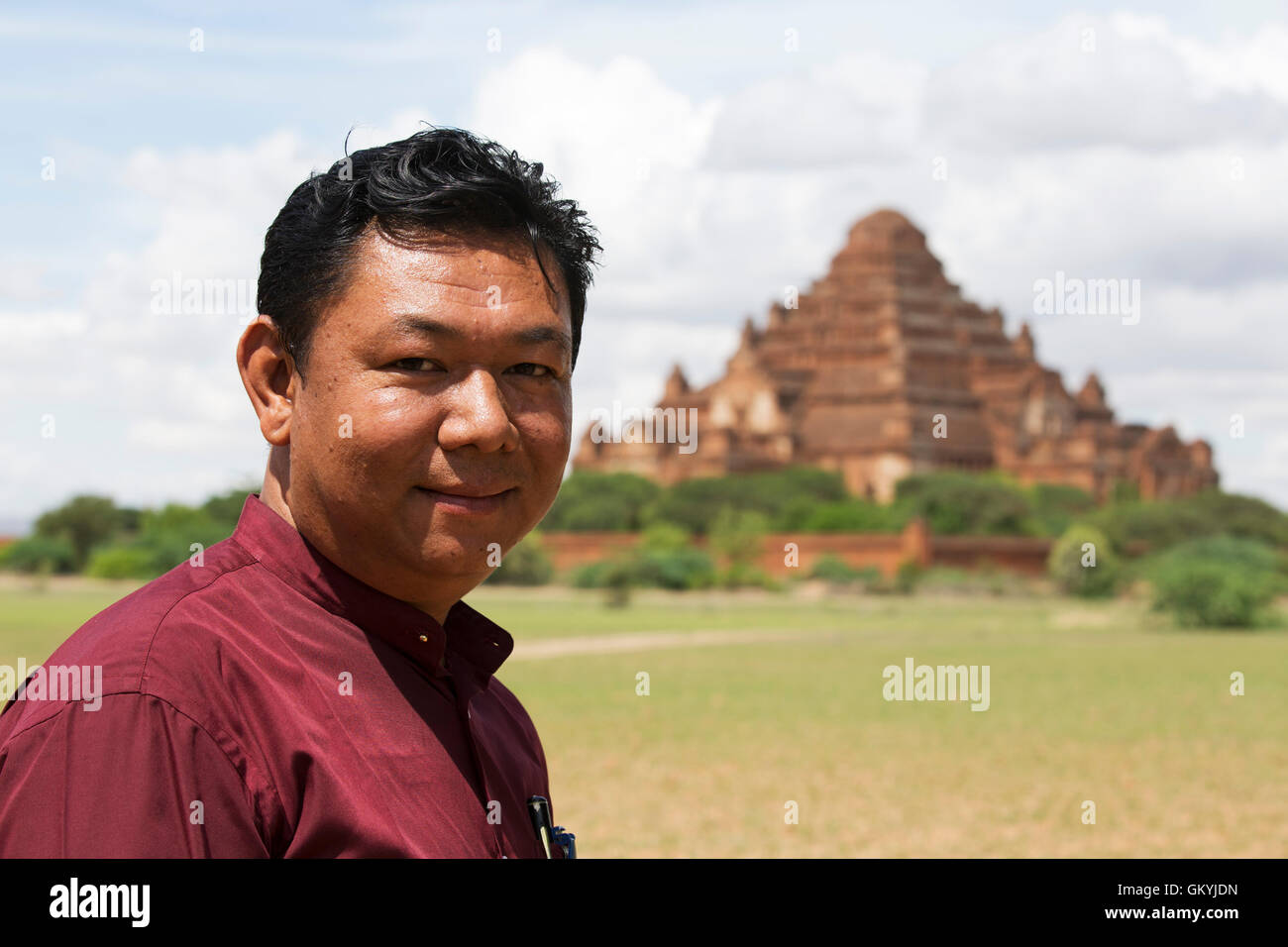 A Burmese man at Bagan, Myanmar (Burma). The man stands in front one of ...