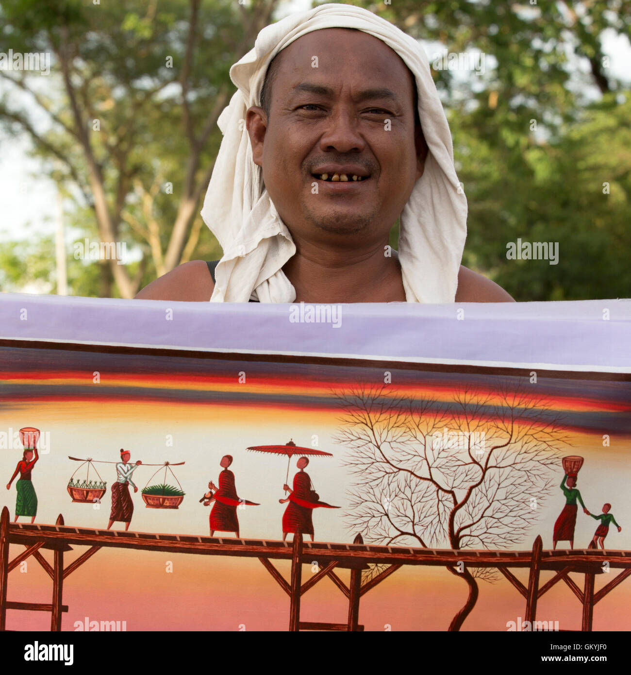 A Burmese hawker holds up a painting at Bagan, Myanmar (Burma). The ...