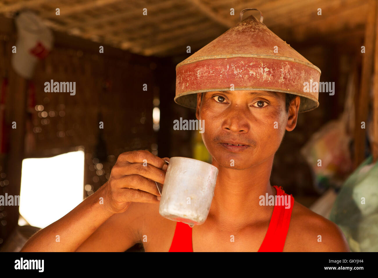 A Burmese man at Bagan, Myanmar (Burma). The man holds a cup of tea and ...