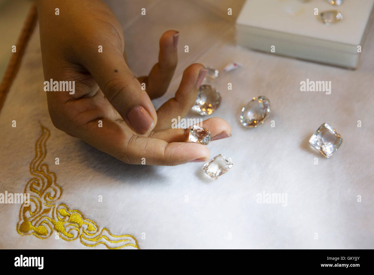 A Burmese woman shows off gemstones at a jeweller's store in Mandalay ...