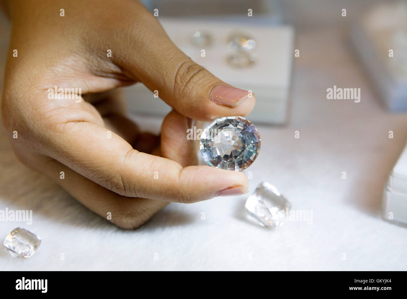 A Burmese woman shows off gemstones at a jeweller's store in Mandalay ...