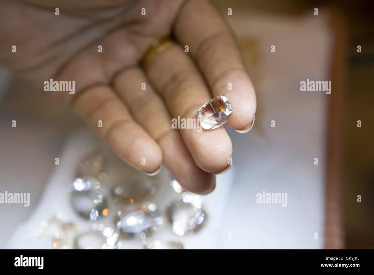 A Burmese woman shows off gemstones at a jeweller's store in Mandalay ...