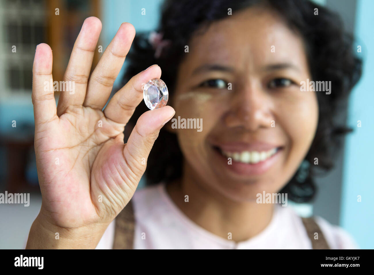 A Burmese woman shows off a gemstone at a jeweller's store in Mandalay ...
