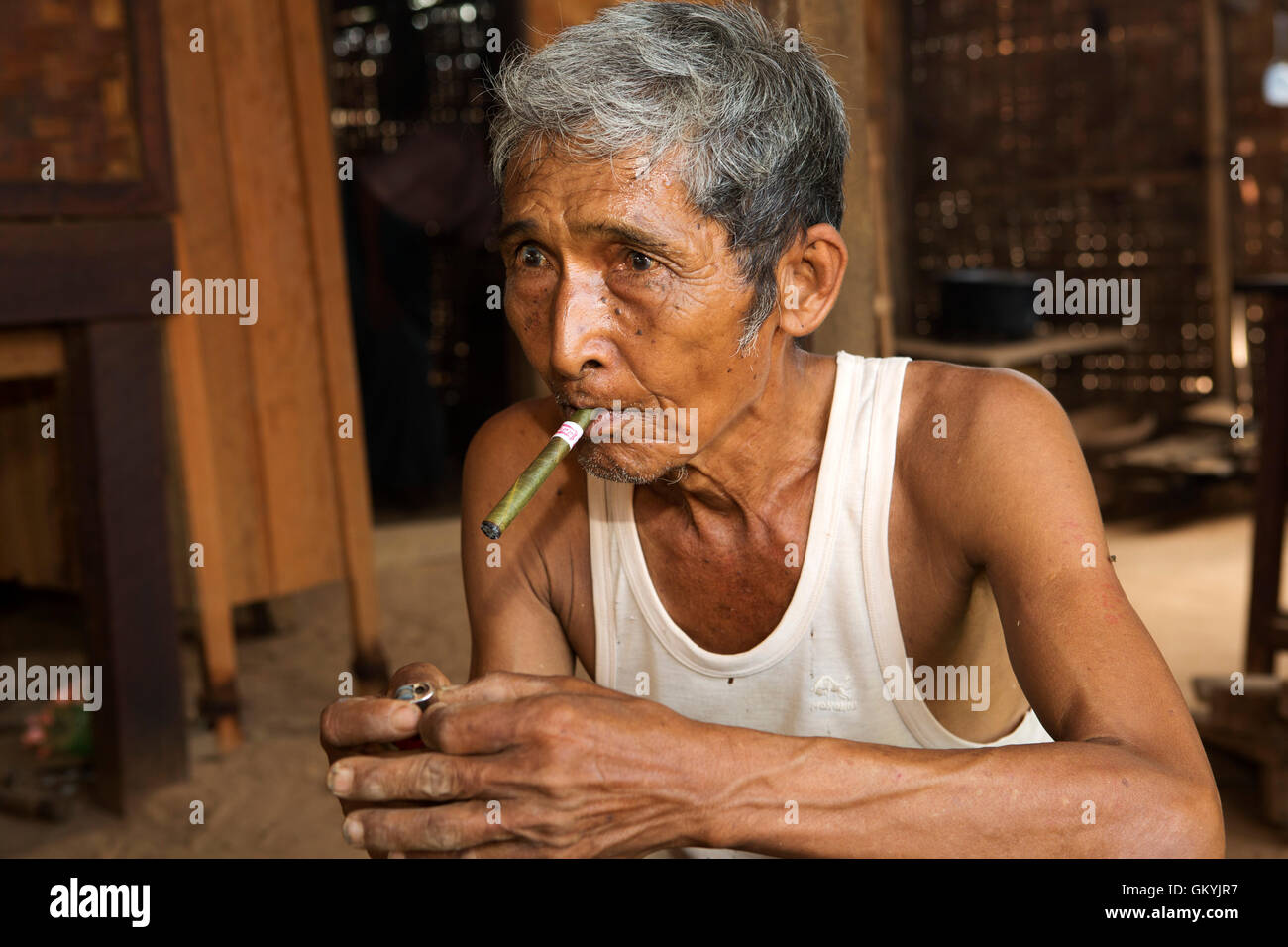 A Burmese man smoking at his house in Minnathu Village near Bagan ...