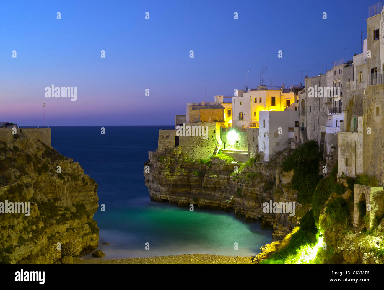 Polignano a Mare at night. Sea and rocks. The old town above the sea ...