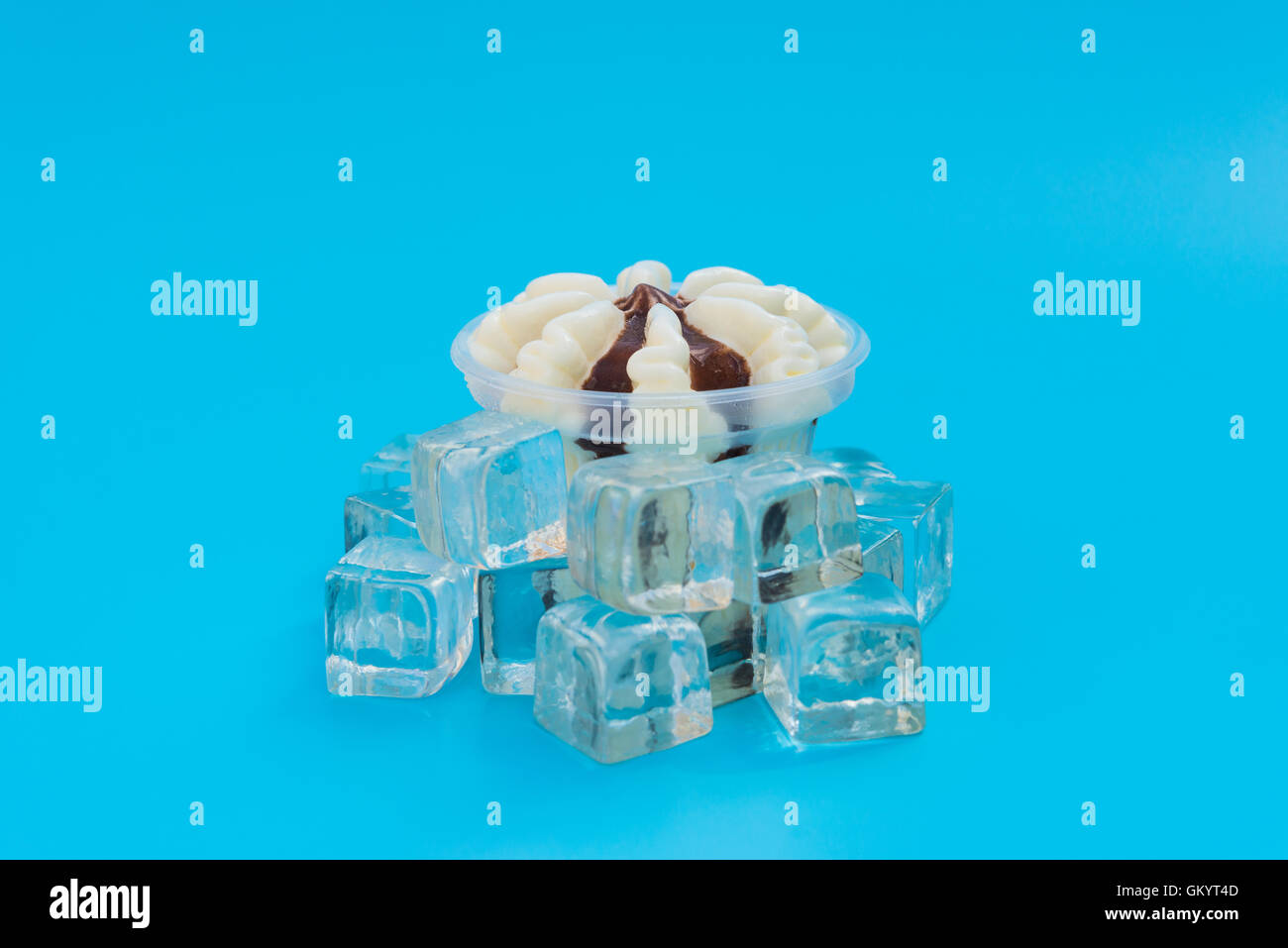 side view cup of chocolate flavor ice cream and ice cube on blue ...