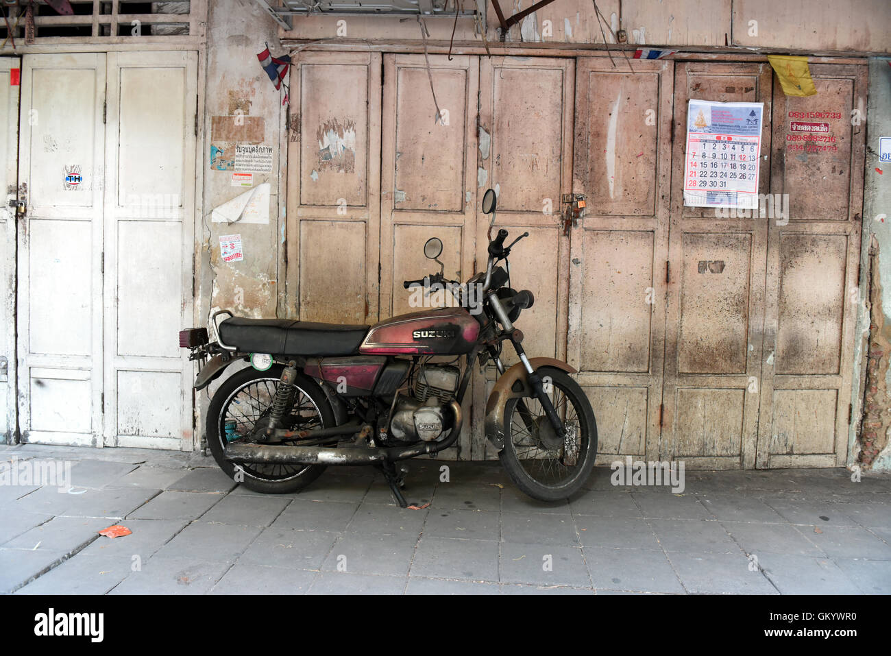 A dirty and rusty motorcycle on a Bangkok sidestreet Stock Photo - Alamy
