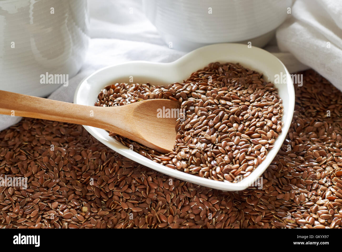 Flax seeds in heart shaped ceramic bowl with wooden spoon Stock Photo - Alamy