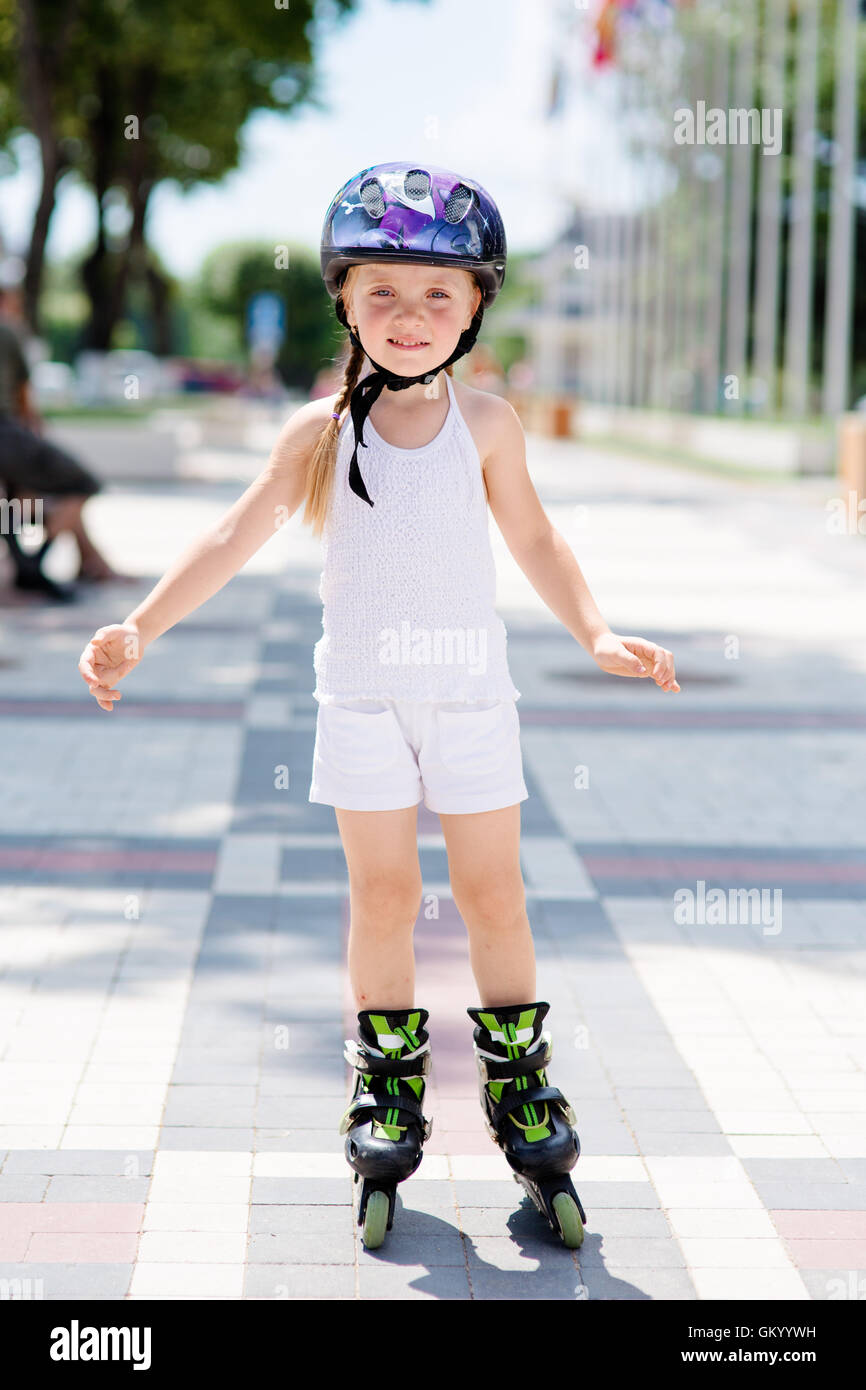 Little girl rides on roller skates at park Stock Photo - Alamy