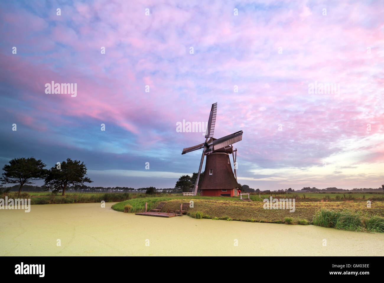 old windmill by lake at sunrise, Holland Stock Photo - Alamy