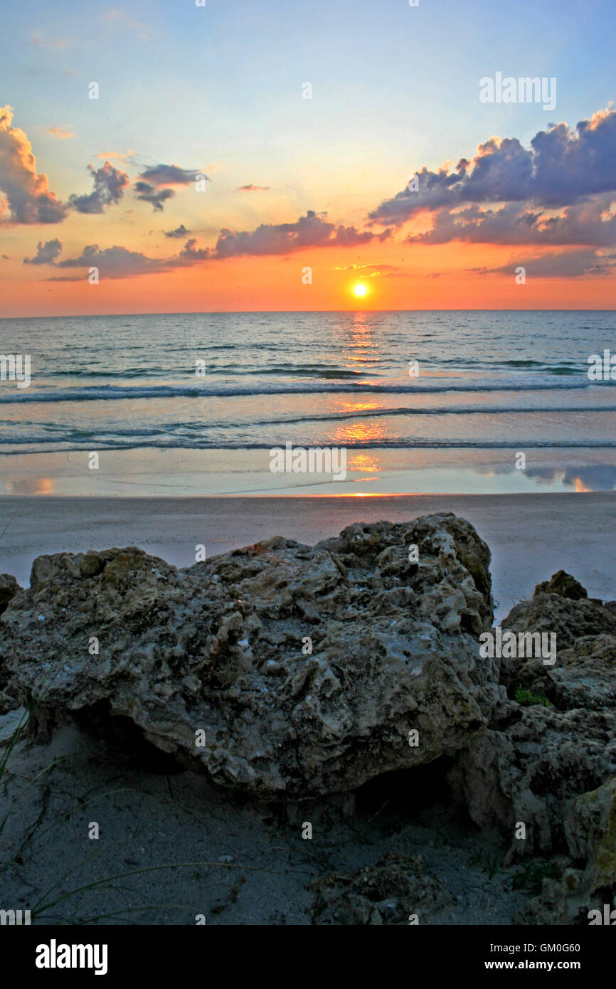 A sunset over the ocean with rocks Stock Photo - Alamy