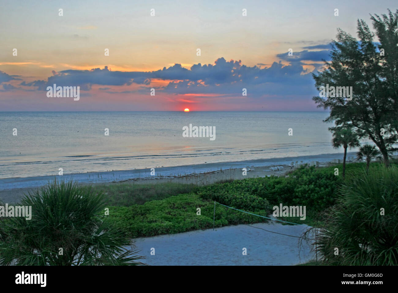 A sunset over the ocean with beach Stock Photo - Alamy