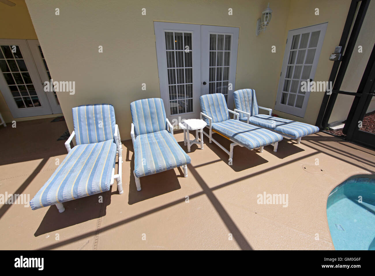 Four pool loungers in a pool area Stock Photo - Alamy
