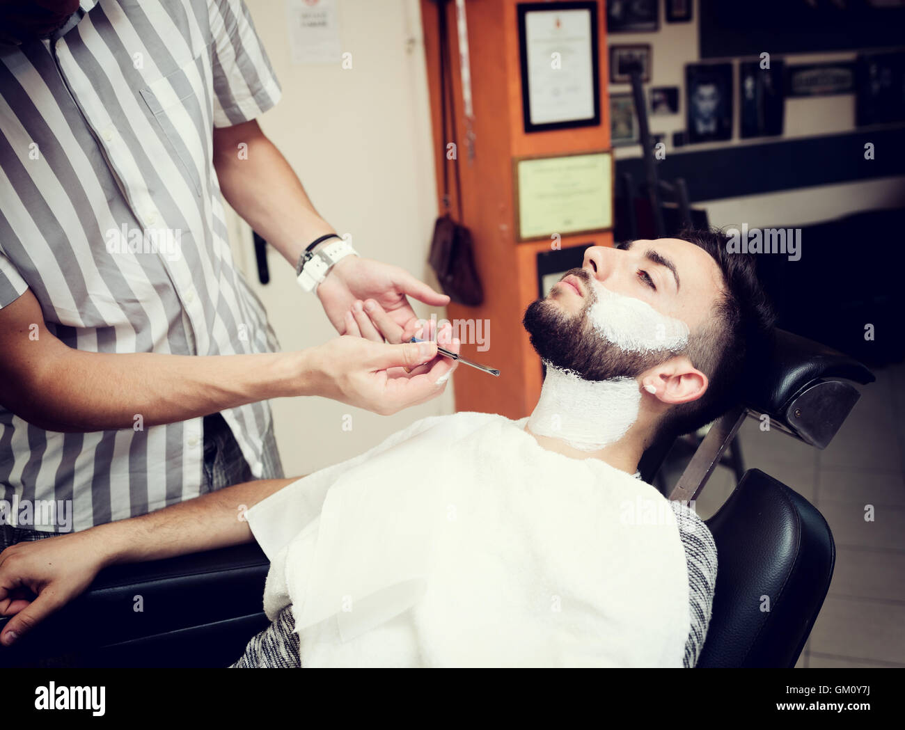 Traditional ritual of shaving the beard in a old style barber shop ...