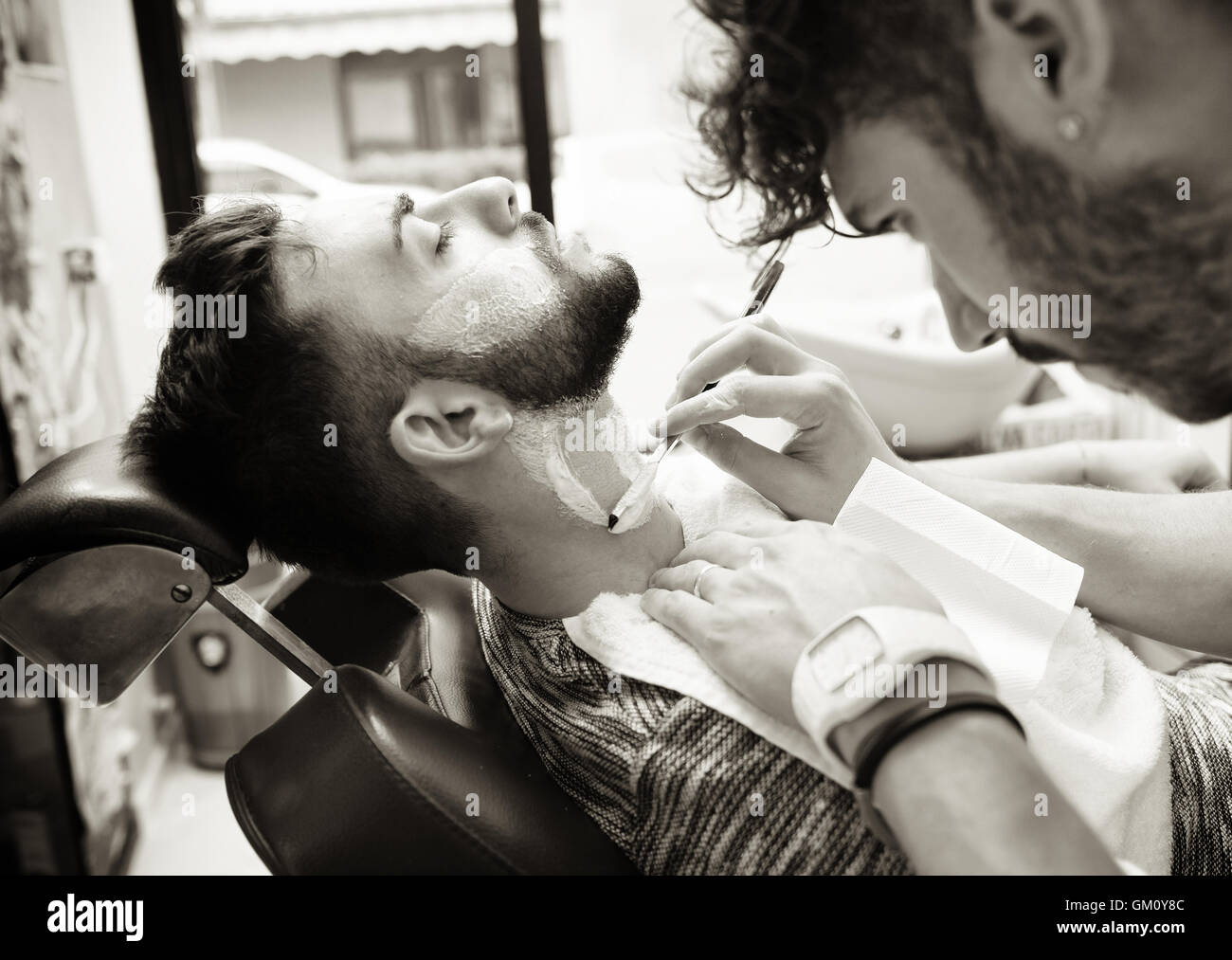 Traditional ritual of shaving the beard in a old style barber shop ...
