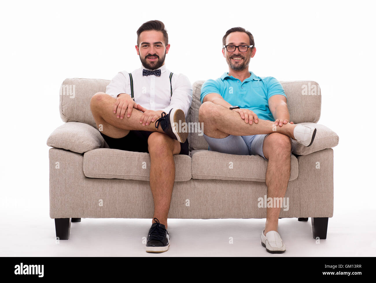 Two excited men sitting on couch Stock Photo - Alamy