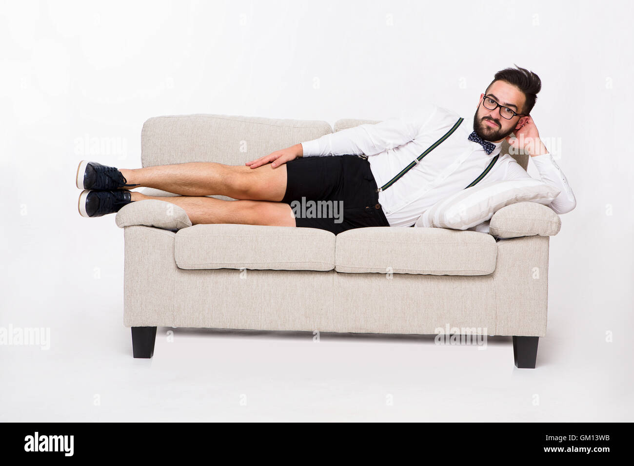 Smiling handsome man lying on couch Stock Photo - Alamy