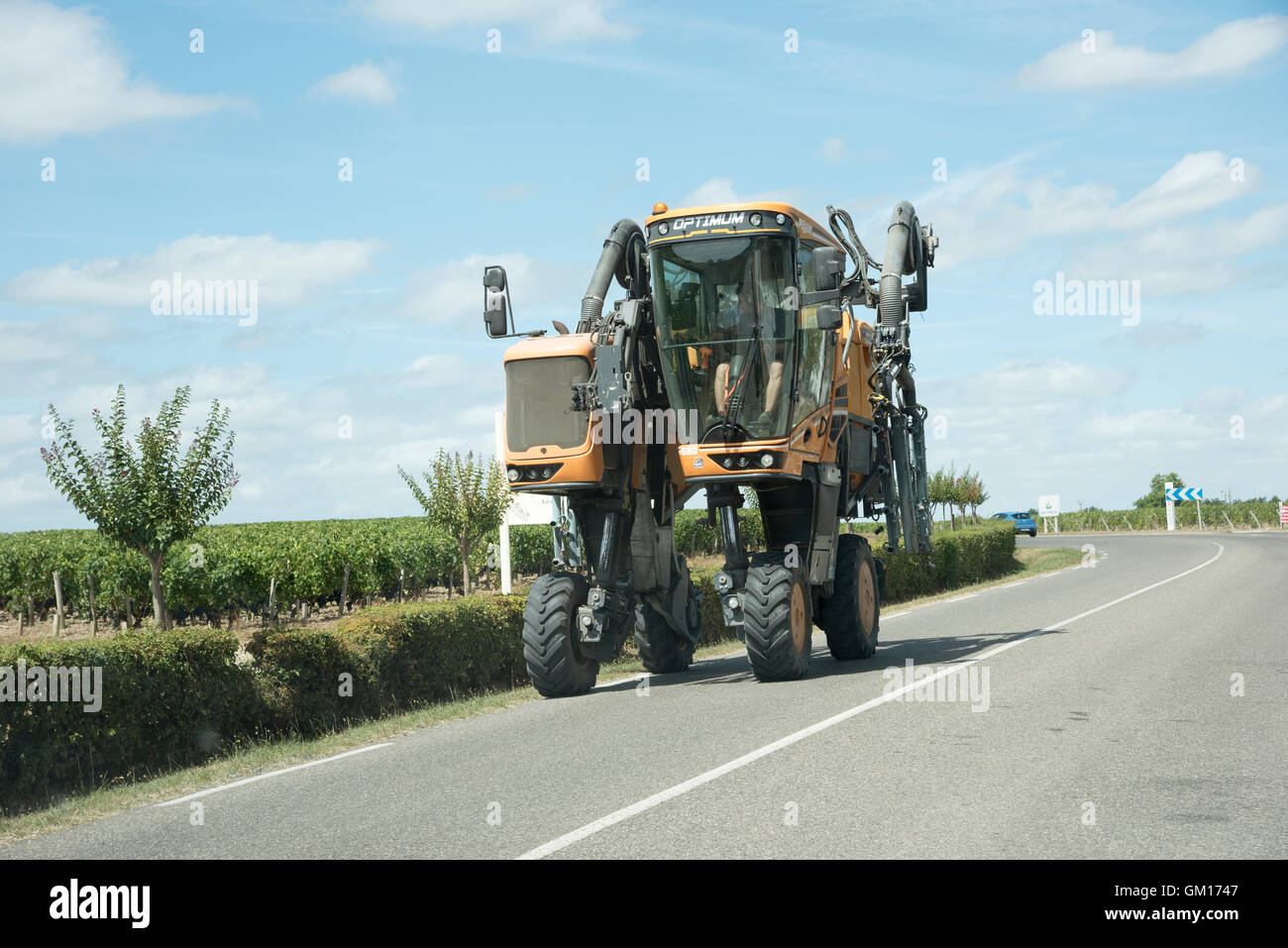 A Straddle tractor with spraying equipment on a public road. Saint ...