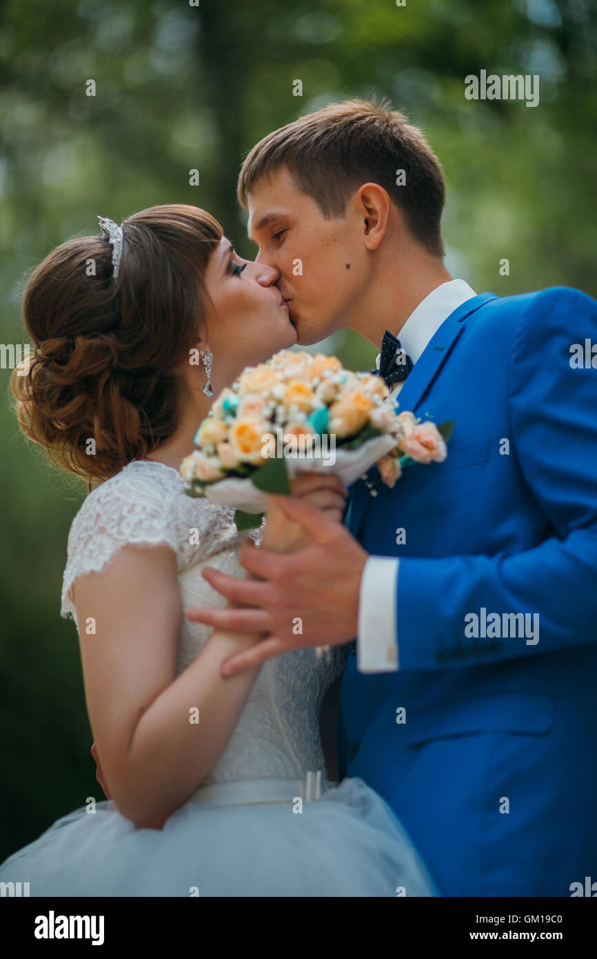young bride and groom kissing on the background of the forest Stock ...