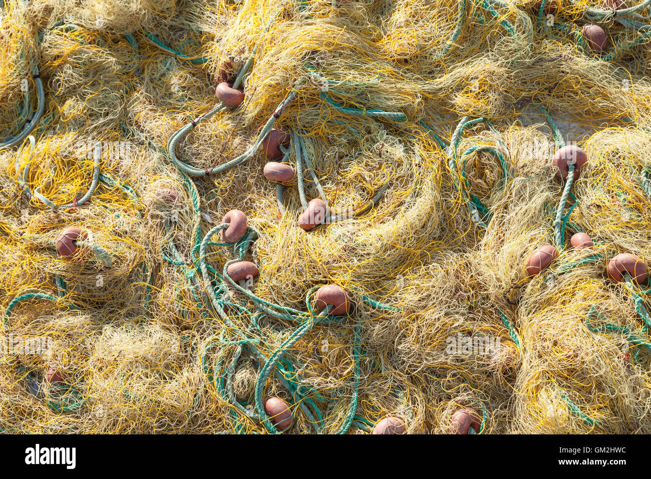 Yellow fishing net with green ropes drying on a pier, background photo ...