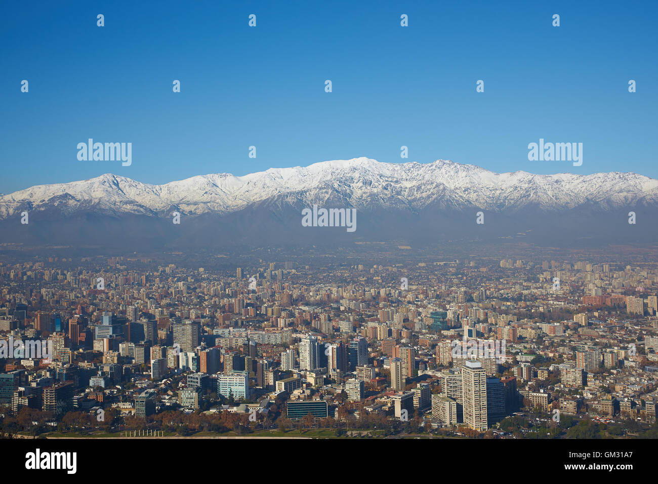 Snow covered mountains surrounding the modern high rise buildings of ...
