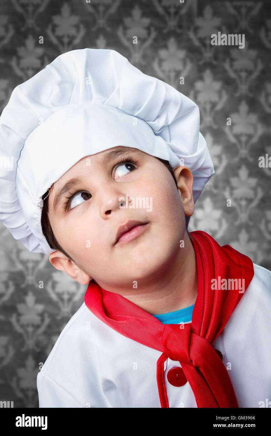 Happy boy cook in uniform over vintage background funny look Stock ...