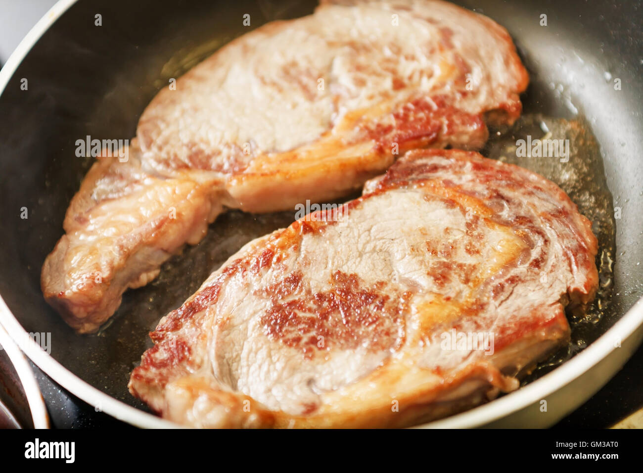 beef steak in a frying pan Stock Photo - Alamy