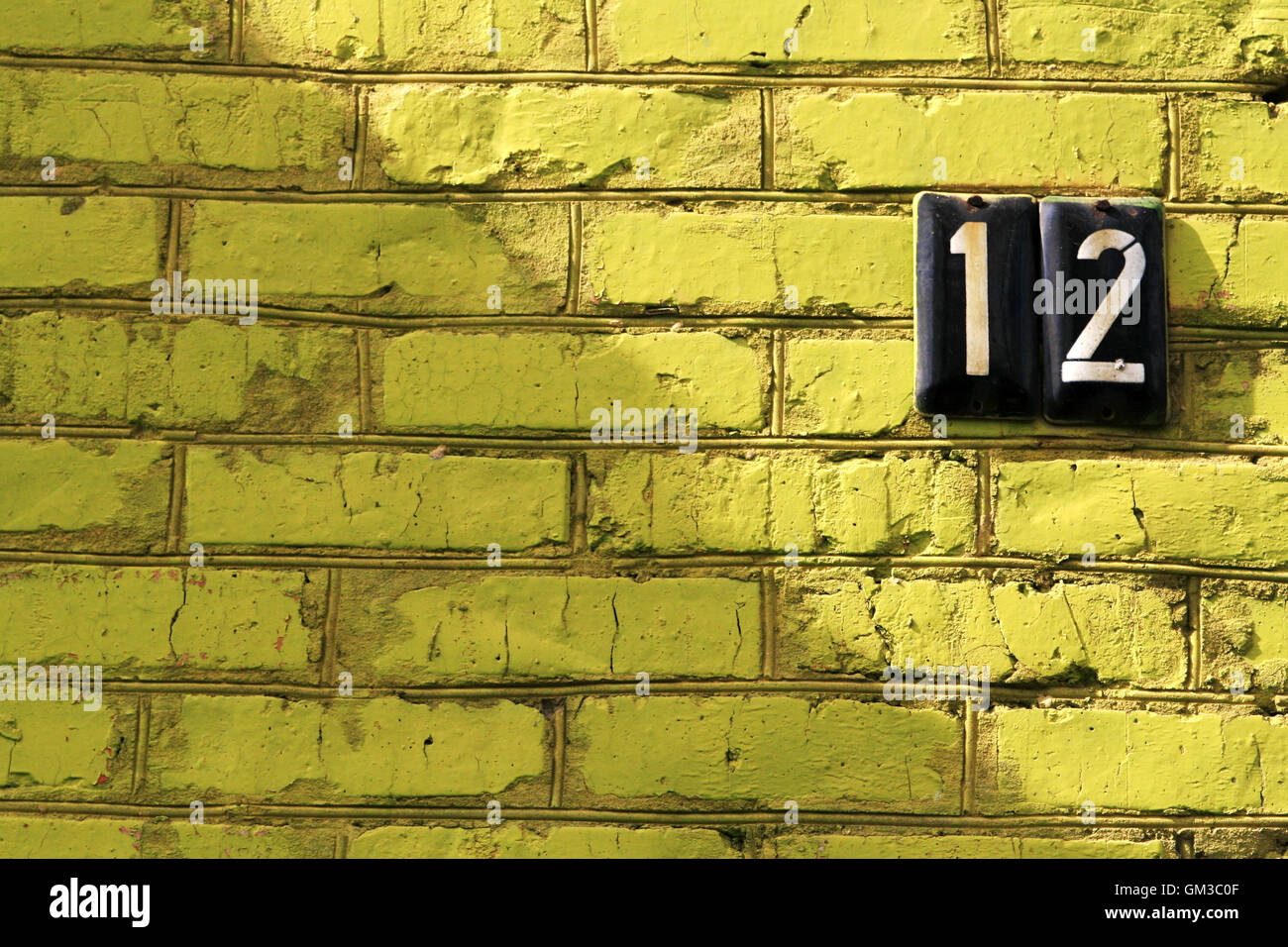 The brick wall that painted in green color, with the number 12 Stock ...