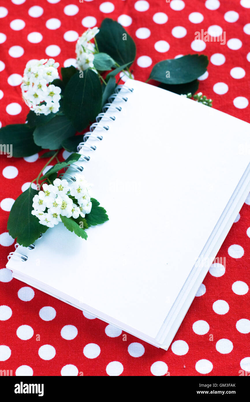 Notebook for notes and a branch with white flowers Stock Photo - Alamy