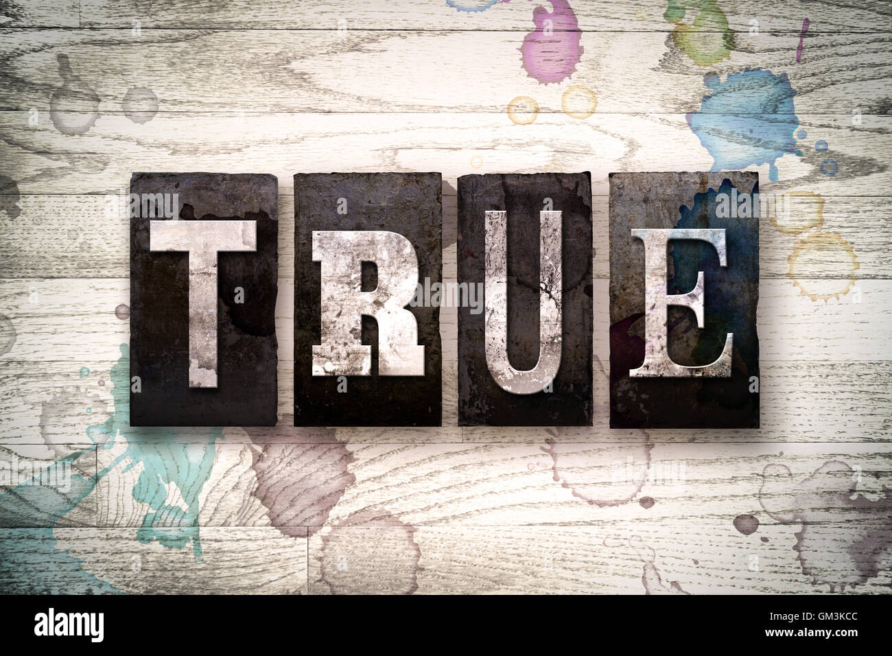 The word "TRUE" written in vintage dirty metal letterpress type on a ...