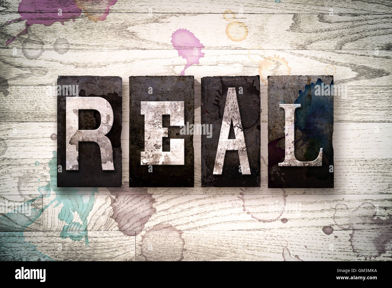 The word "REAL" written in vintage dirty metal letterpress type on a ...