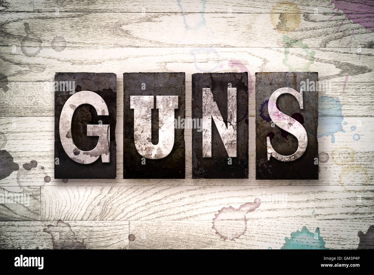 The word "GUNS" written in vintage dirty metal letterpress type on a ...