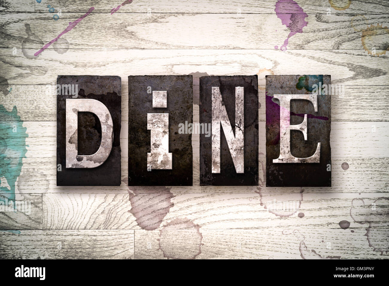 The word "DINE" written in vintage dirty metal letterpress type on a ...