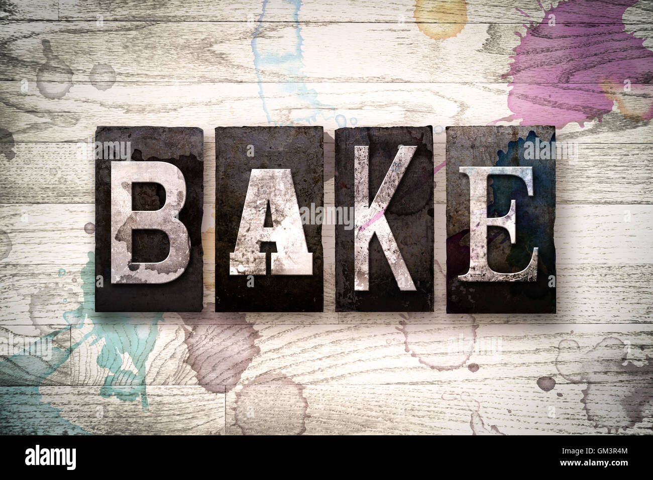 The word "BAKE" written in vintage dirty metal letterpress type on a ...