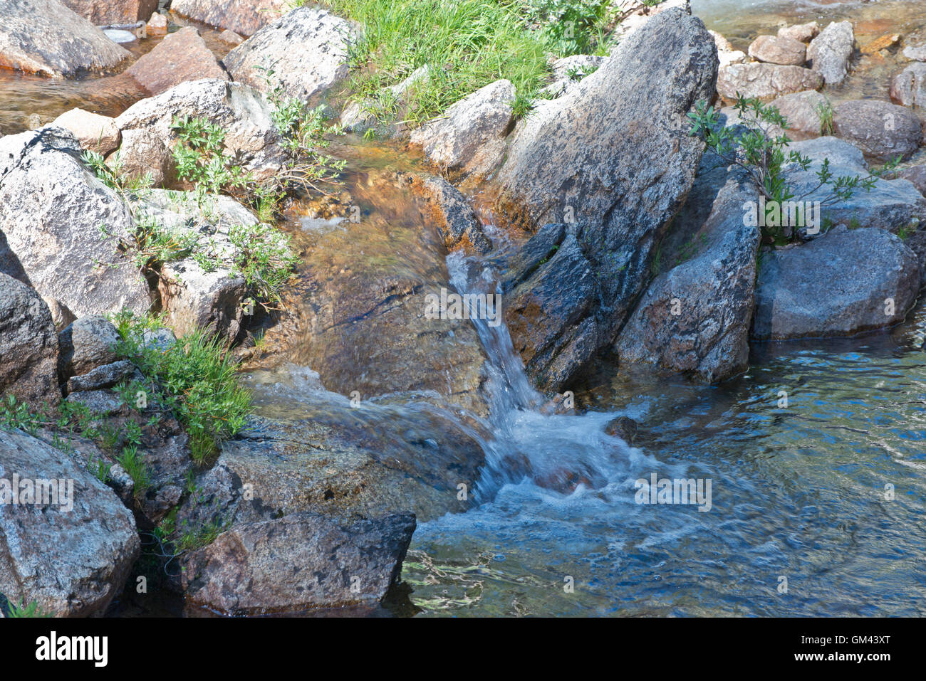Creek flowing into a rock surrounded pool Stock Photo - Alamy