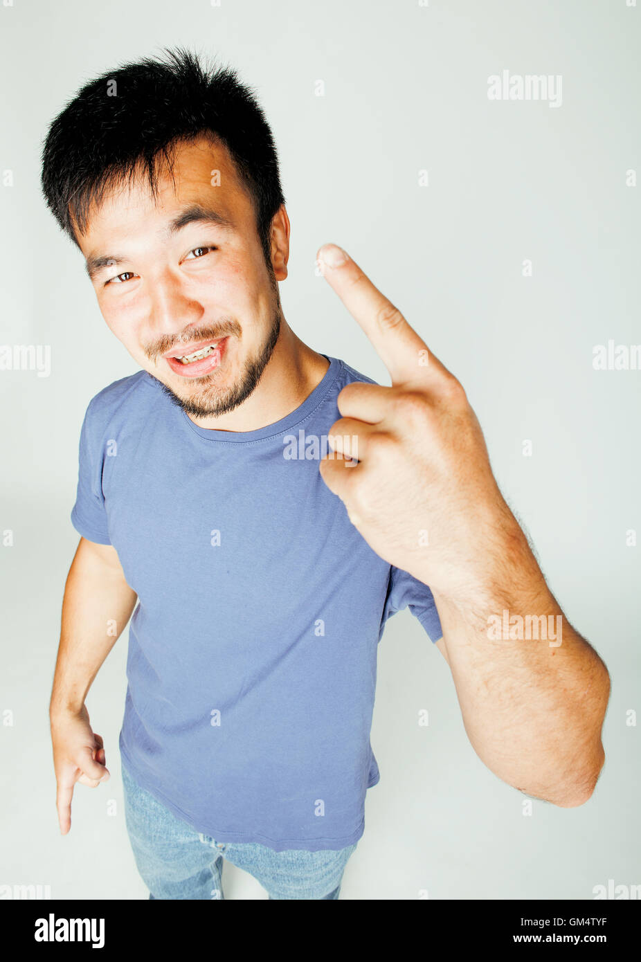 young cute asian man on white background gesturing emotional, pointing ...
