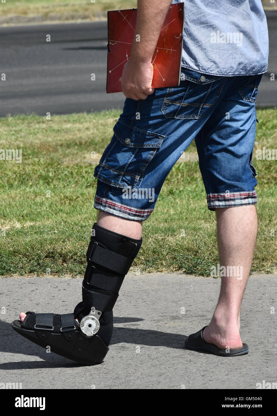 Man with broken leg on the street Stock Photo - Alamy