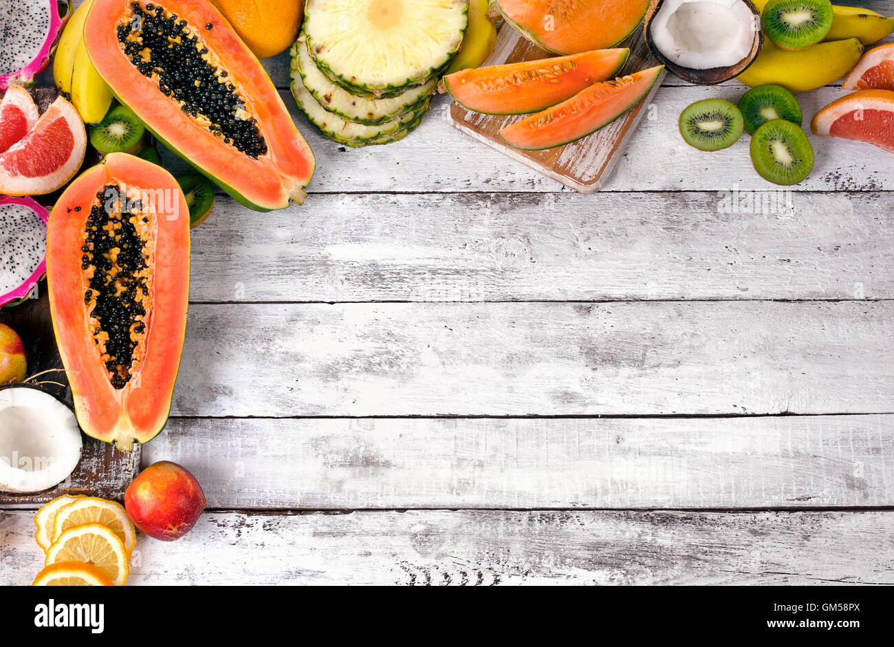 Different raw Exotic tropical fruits on a white wooden background ...