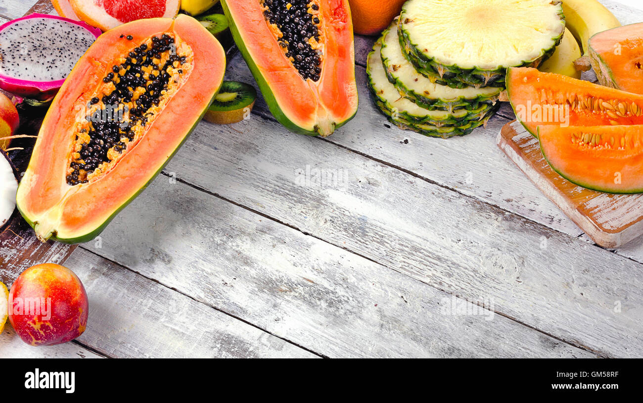 Different raw Exotic tropical fruits on a wooden background. Healthy ...