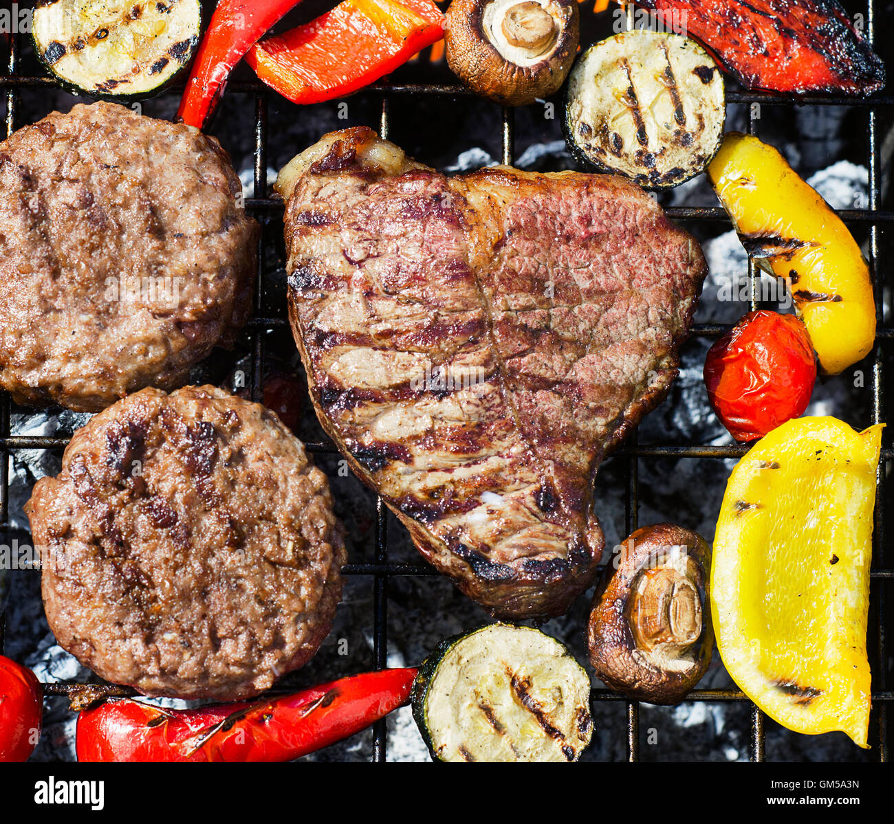 Meat with vegetables on grill. Top view Stock Photo - Alamy
