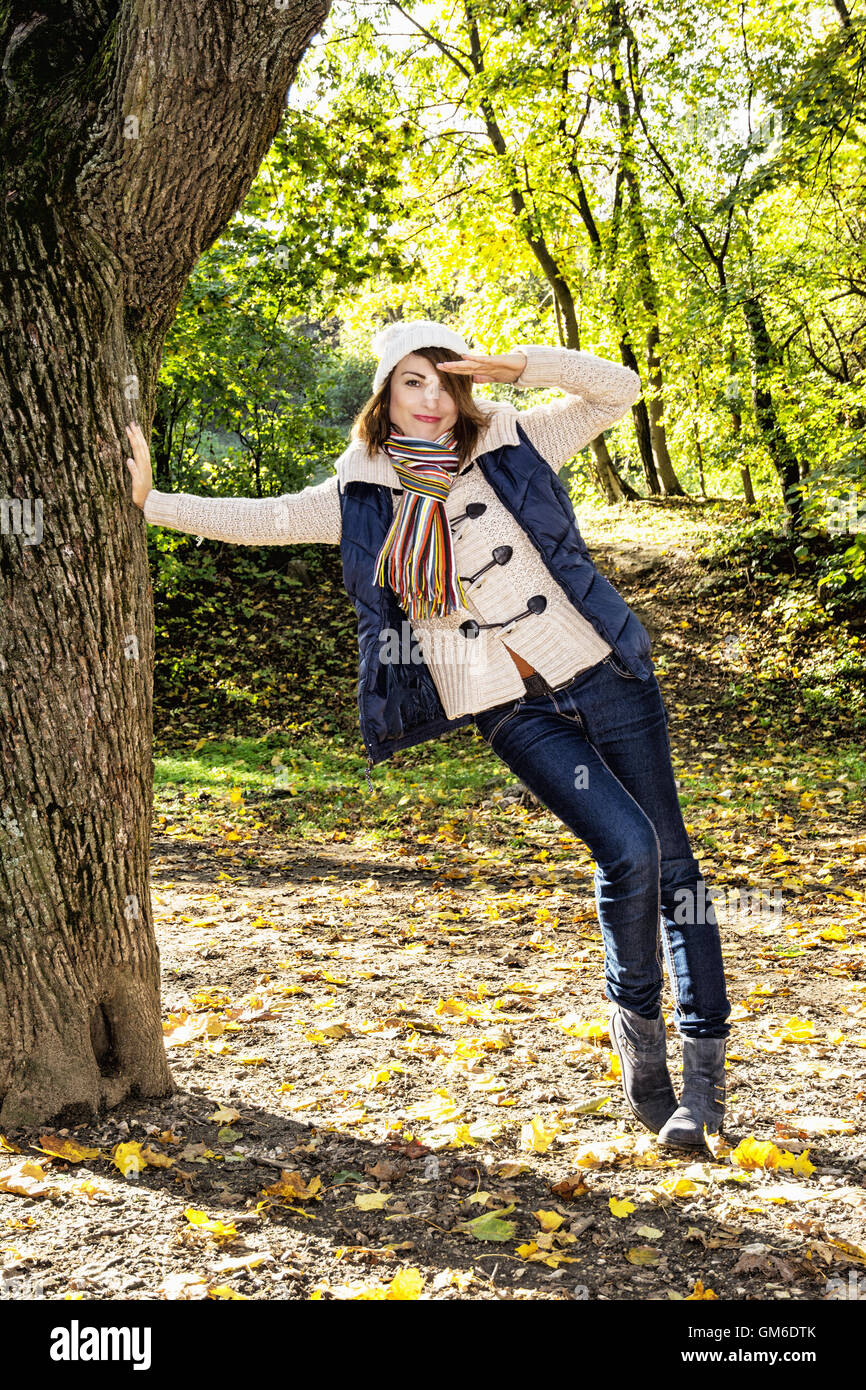 Beautiful young positive woman saluting under the beech tree in autumn ...