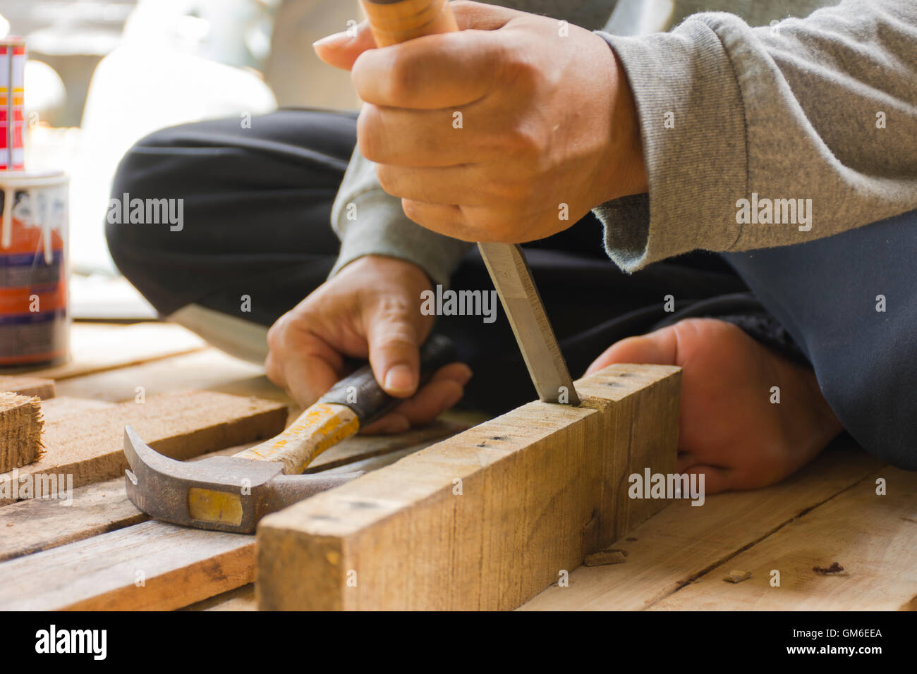 Carpenter using chisel and hammer in his hand with plank.Close up and ...