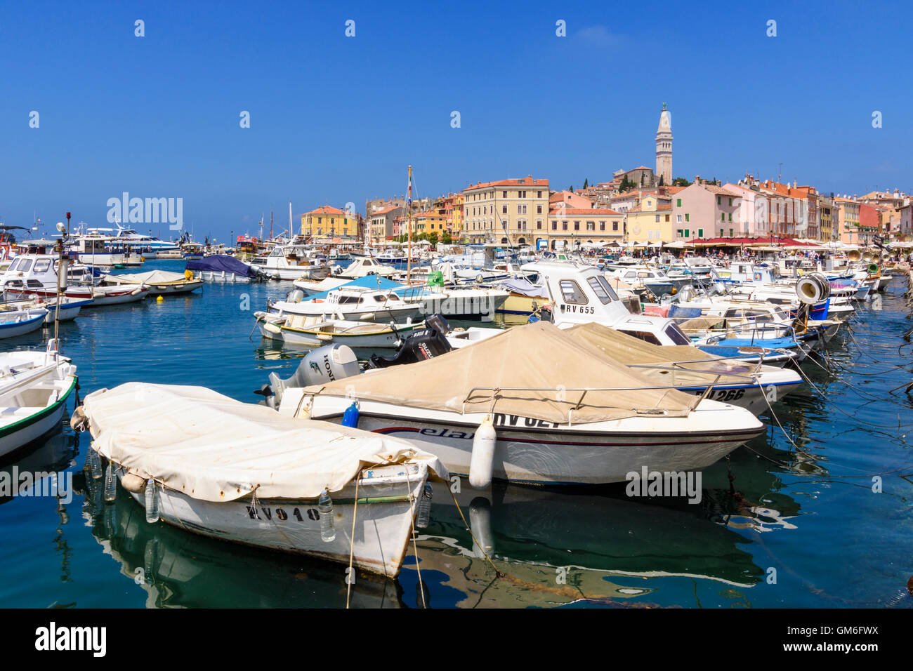 Moored boats in the harbour of Rovinj Town, overlooked by the colourful ...
