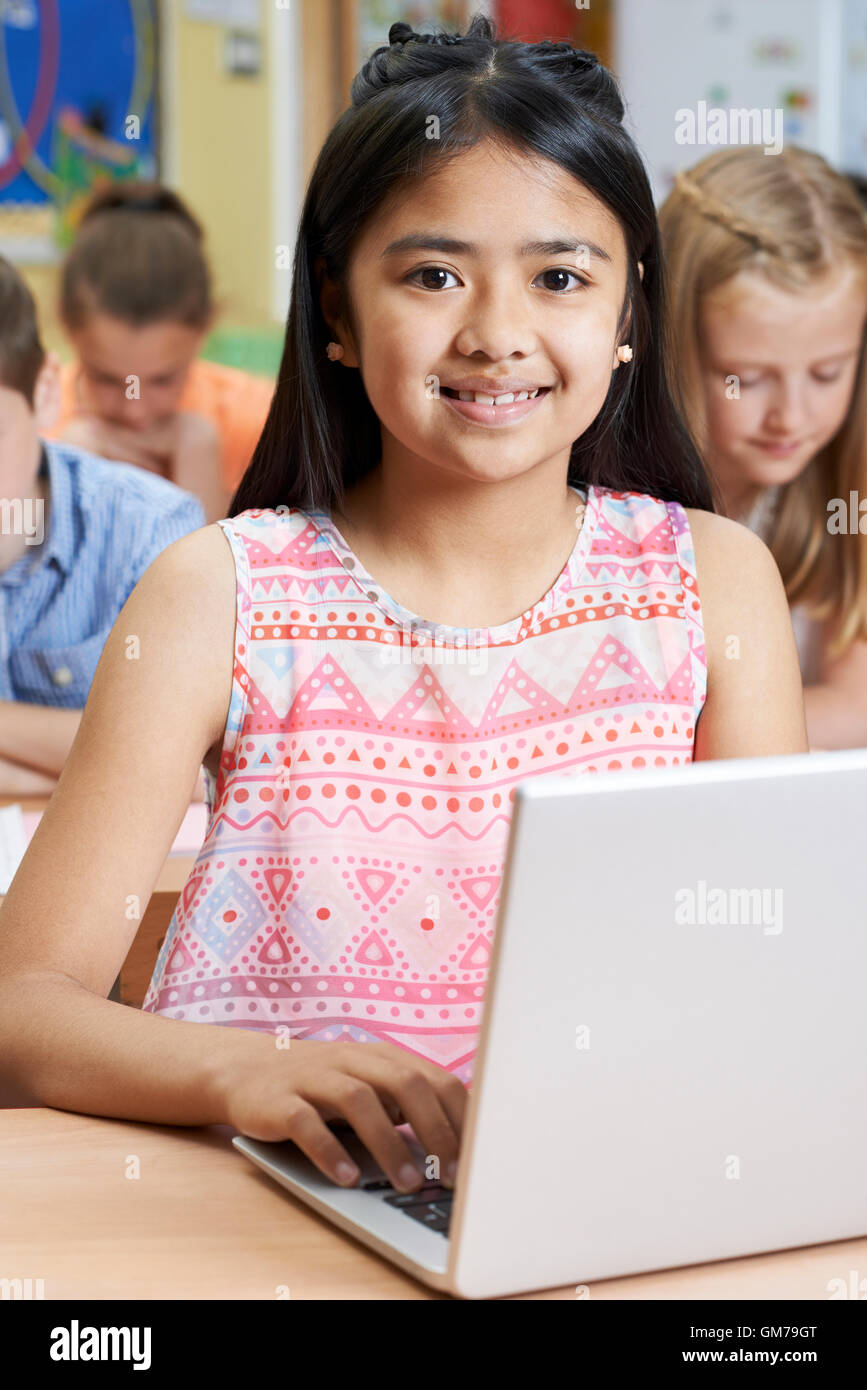 Female Elementary School Pupil Using Laptop In Computer Class Stock ...