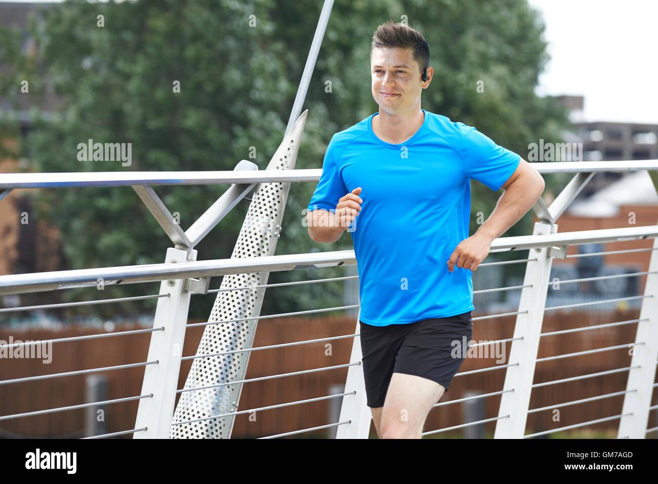 Young Man Running In Urban Setting Listening To Music Stock Photo - Alamy