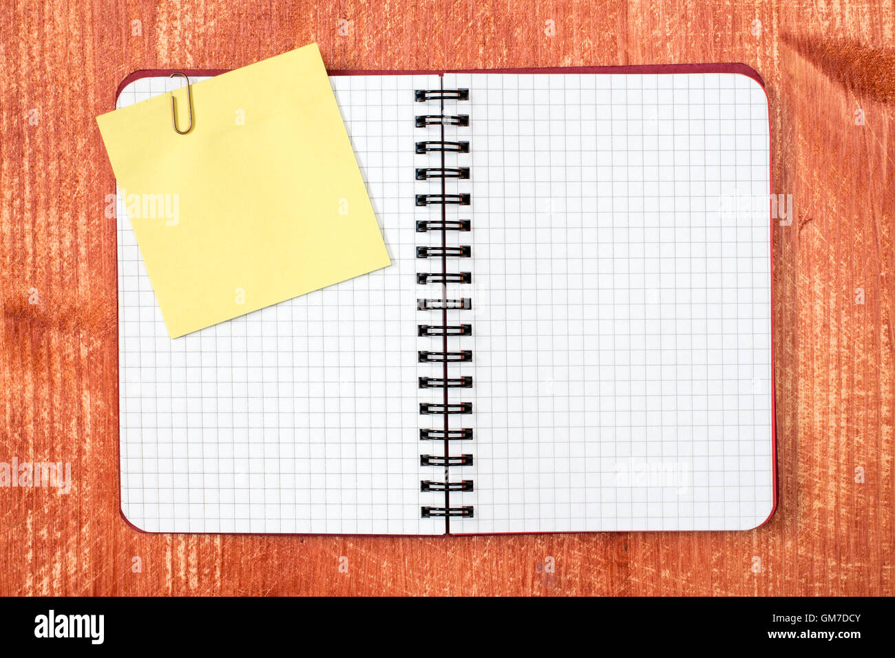Open notebook with sticky note on red wooden background Stock Photo - Alamy